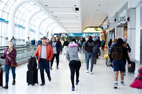 Rear View Diverse Group Of Passengers With Luggage And Backpack Walking