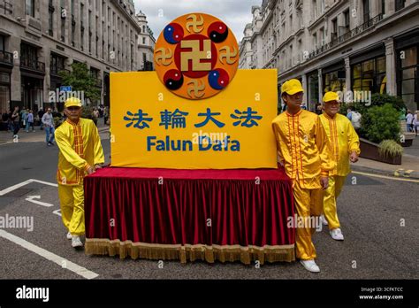 London Uk 23rd Aug 2025 Members Of The Falun Going Movement Wheel A Sign Along A Street