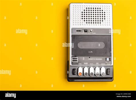 Vintage Portable Tape Recorder With Open Cover And Compact Cassette Inside Compartment On Yellow