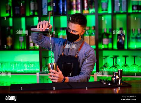 Young Guy A Working As A Bartender While Preparing Cocktails In A Pub