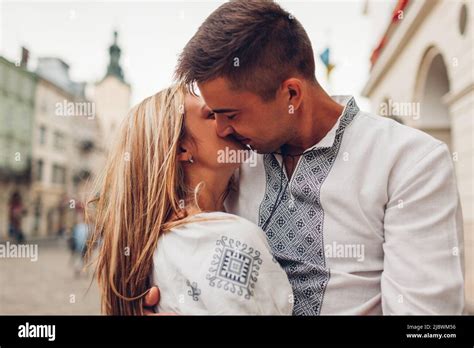 Young couple in love kissing in old Lviv city wearing traditional ukrainian shirts. Man and ...