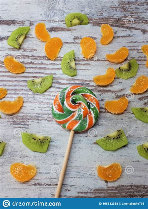 Close Up Of A Large Round Fruit Candy On A Background Of Slices Of Kiwi