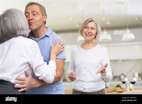 Two Elderly Couples Meet For Holiday Dinner At Home Greet Each Other