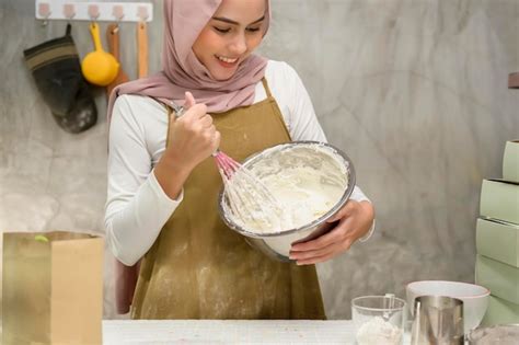 Premium Photo Young Beautiful Muslim Woman Is Baking In Her Kitchen