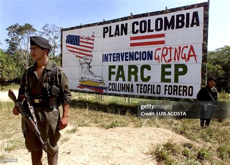 Two Guerrillas Of The Revolutionary Armed Forces Of Colombia Stand