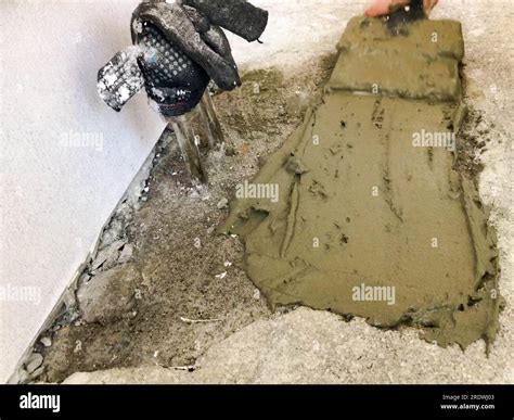 Builder Hands With A Metal Spatula Plaster The Wall Pours The Screed