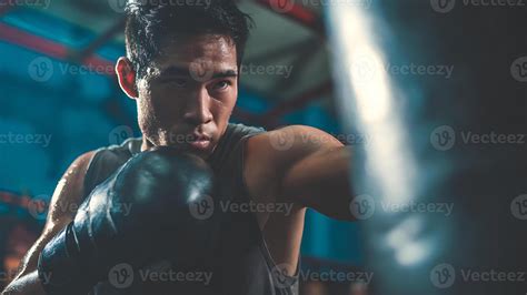 Intense Male Boxer With Sweat On Face Training In A Dark Boxing Gym