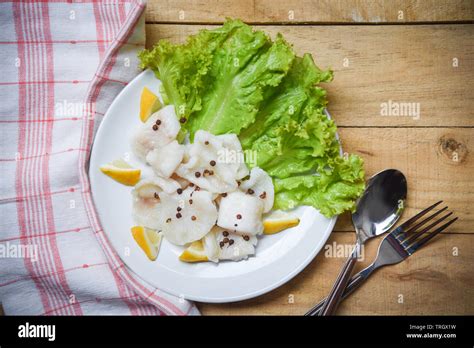 Cooked Fish Fillet Piece With Lemon And Spices On White Plate Wooden