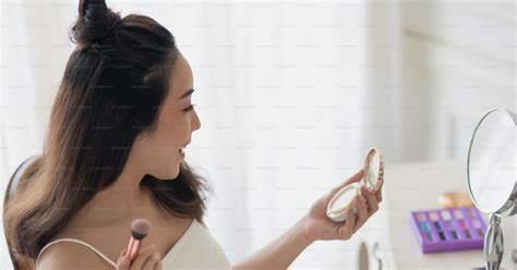 행복한 여자는 거울을 보고 집에서 광대뼈에 브러시로 화장품을 바르고 있다 블로거 재미 사진 Unsplash의 파우더 도포 이미지