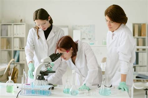 Scientists Engaging In Microscopic Analysis In Laboratory Setting Stock