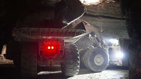 Underground Loader Loads Ore Mass Into An Underground Dump Truck Stock