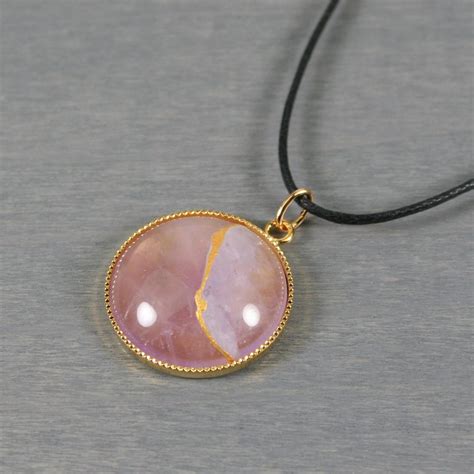 Kintsugi Repaired Amethyst Pendant In A Gold Setting On A Black Cotton