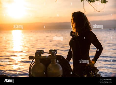 Female Scuba Diving Instructor Wearing A Wet Suit Standing Next To A