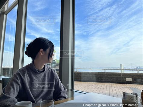 窓際のテーブルに座っている人の写真・画像素材 Snapmart（スナップマート）