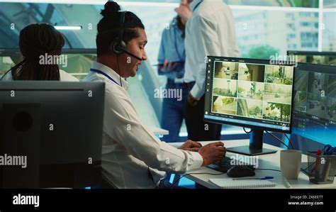 Indian Employee Communicating Satellite Map Directions In Observation Room Monitoring Traffic
