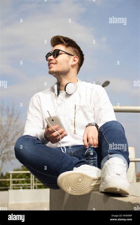Handsome Young Man Sits And Enjoys The Outdoors Surf The Internet And