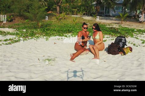 Young Beauty Models Relaxing By The Sea On The Beach On Clean White