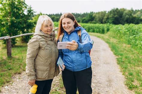 Happy Two Explorers Using Mobile Phone For Navigation Outdoors Travel