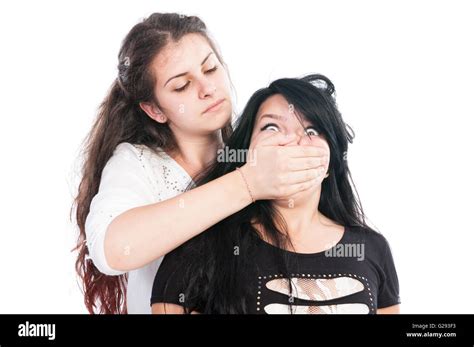 Older Girl Bullying Her Younger Friend By Covering The Mouth Using Hand