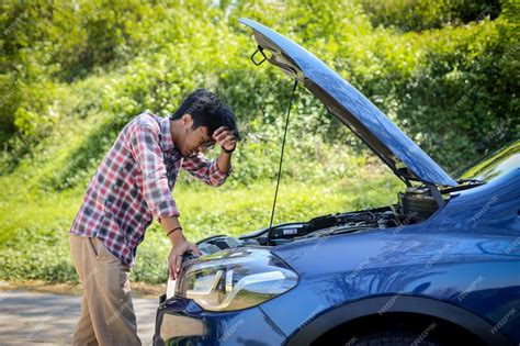 Premium Photo Man Try To Fix A Car Engine Problem On A Local Road Car
