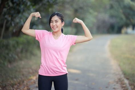 Premium Photo Smiling Young Woman Standing Against Blurred Background