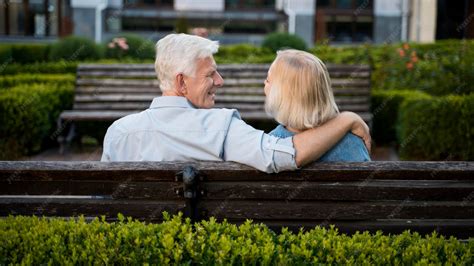 Free Photo Back View Of Embraced Older Couple Outdoors On Bench