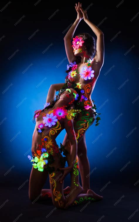 Premium Photo Nude Women With Glow Uv Body Art And Flowers