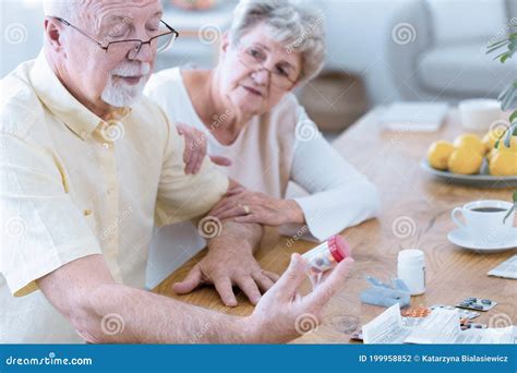 Elder Man Reading A Label Of A Drug Sitting Next To His Wife Stock Photo Image Of Married