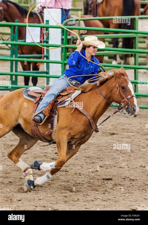 Rodeo Cowgirl On Horseback Competing In Calf Roping Or Tie Down Roping