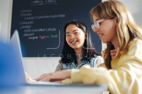 Happy Young Girls Sitting In A Coding Class Learning Basic Programmin