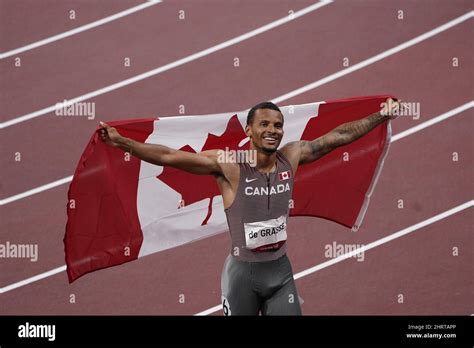Canadas Andre De Grasse Celebrates Wth The Canadian Flag After Racing