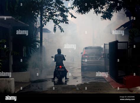 A Motorist Stops While A Health Workers Fumigate A Residential Area To