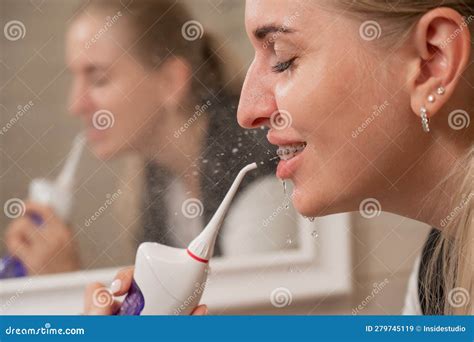 A Woman With Braces On Her Teeth Uses An Irrigator Close Up Portrait