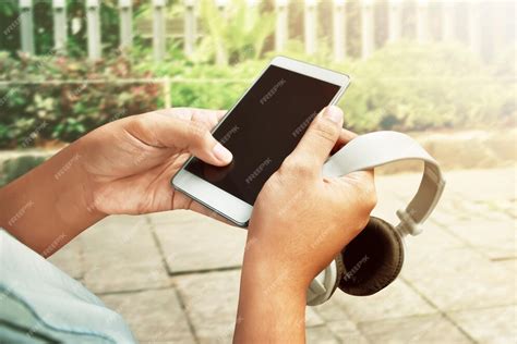 Premium Photo Hand Holding Smartphone And Headphones