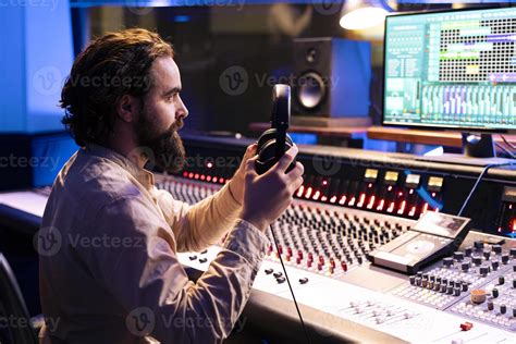 Audio Technician Putting Headphones On To Listen To Final Track In