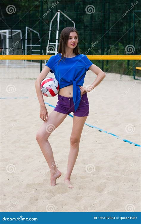 Slender Beautiful Girl On The Beach With A Volleyball Ball In Hands