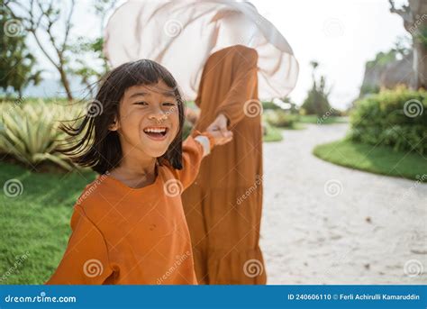 Madre Musulmana E Hija Caminando Y Cogiendo La Mano Foto De Archivo