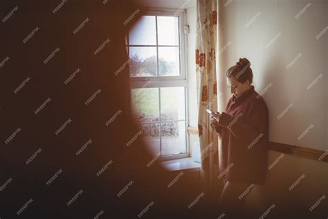 Free Photo Woman Using Mobile Phone Near Window At Home