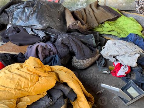 Piles Of Various Types Of Clothing And Blankets Clutter An Abandoned