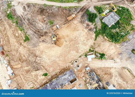 Aerial Top Down View Of An Excavator And Dump Trucks Working On