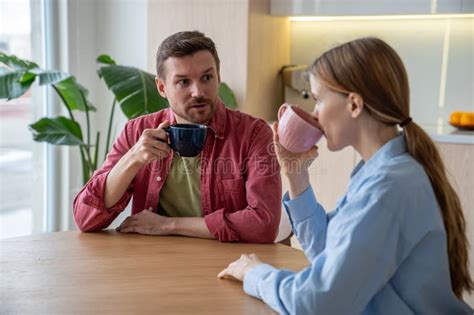 Passionate Couple Enjoys Cozy Moment At Home Sipping Coffee Engaging In Heartfelt Conversation