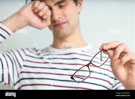 Young Man With Eyeglasses On Light Background Closeup Glaucoma