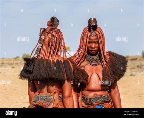 Two Women Of The Himba Tribe Face Each Other In Traditional Dress And