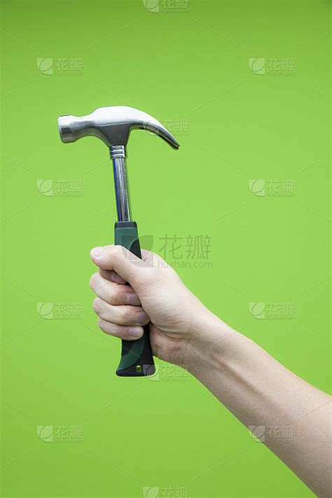 绿色背景上，一只手拿着羊角锤