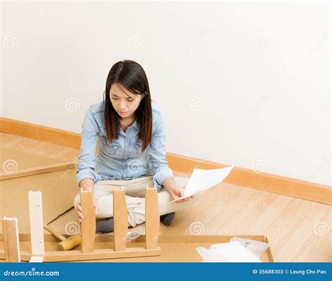 Asian Woman Assembling Chair By Hammer With Instruction Stock Image