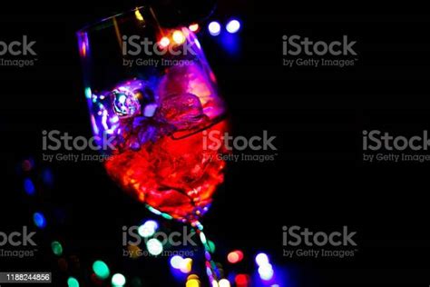 얼음 조각과 고립 된 빨간 칵테일 유리의 닫습니다 전기 조명에서 다채로운 활기찬 보케와 검은 배경입니다 0명에 대한 스톡 사진 및 기타 이미지 Istock
