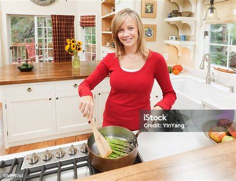 Young Woman Homemaker Cooking Vegetable In Residential Home Kitchen