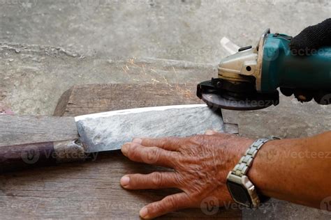 Closeup Hands Are Sharpening A Knife With Electric Sharpener Grinder