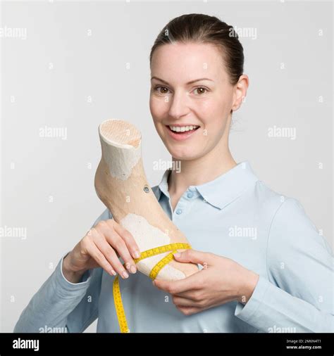 A Young Female Shoemaker Presenting An Individual Crafted Last Stock