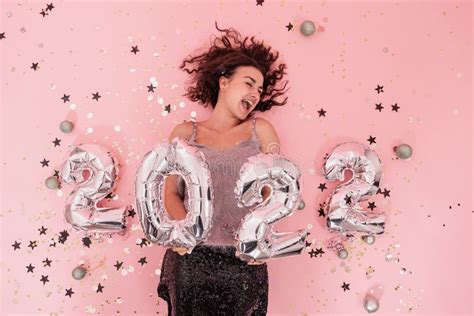 A Girl On A Pink Background With Silver Balloons From Numbers 2022 Top